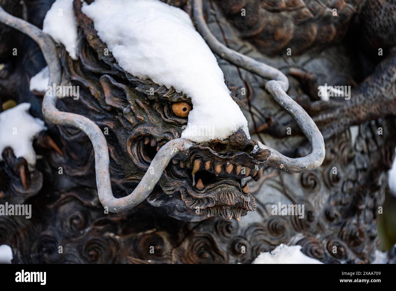 A menacing dragon statue covered in snow at the ancient sacred ...