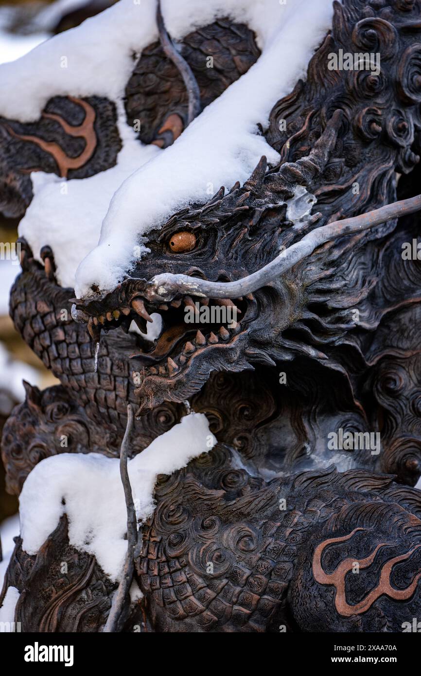 A menacing dragon statue covered in snow at the ancient sacred ...
