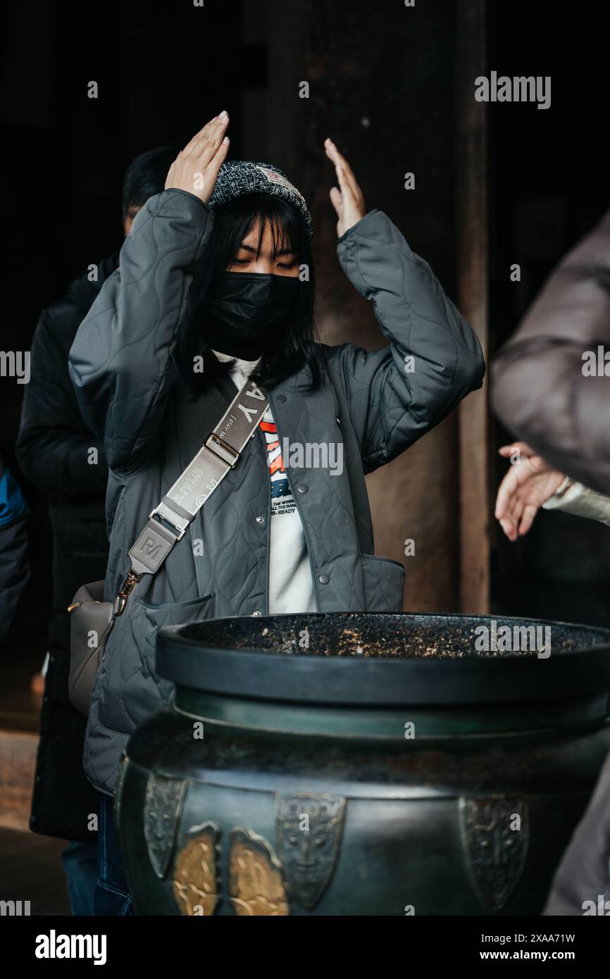 A women praying and wafting smoke for wishes and good luck ...