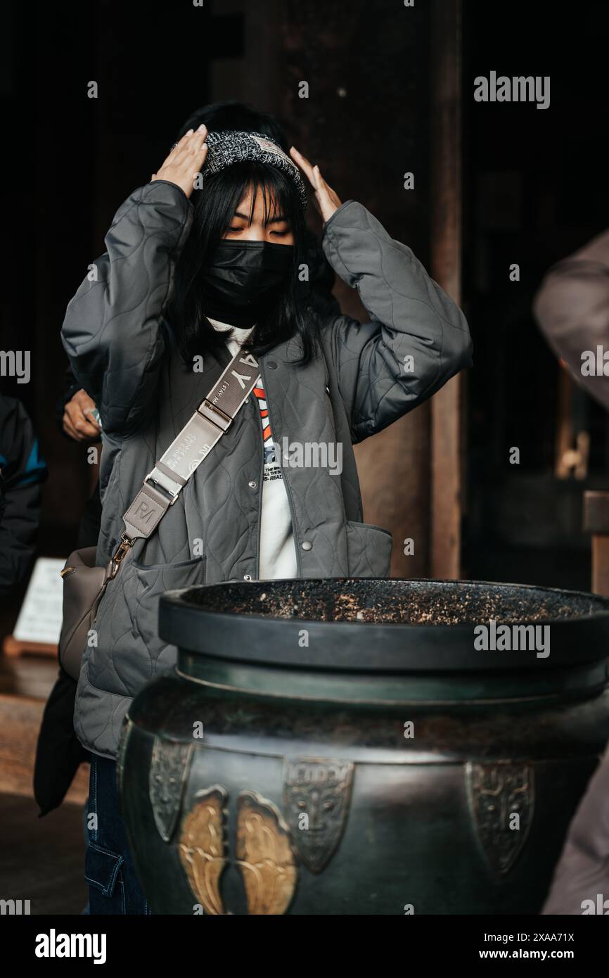 A women praying and wafting smoke for wishes and good luck ...