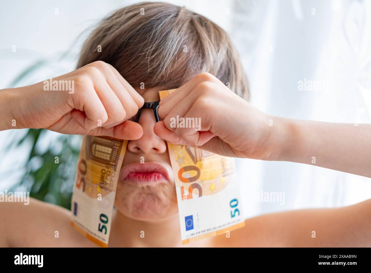 child inserted euro banknotes into glasses, euro money, rejoices in ...