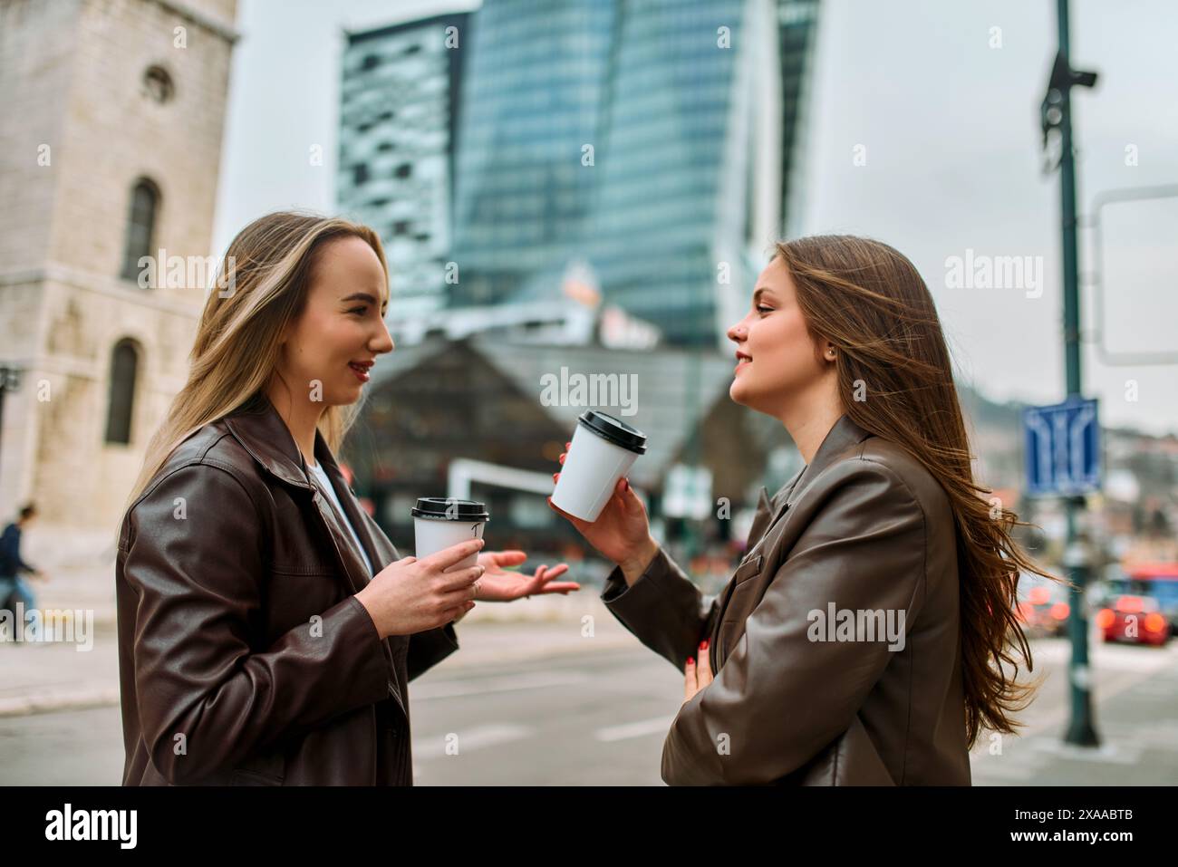Two businesswomen enjoying a coffee break outside their office Stock ...