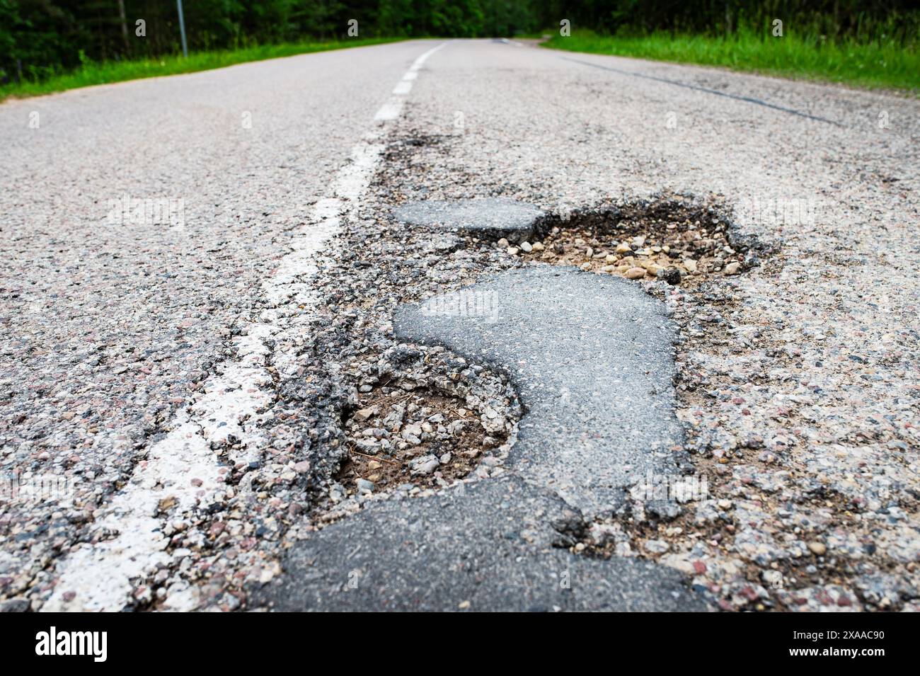 The texture of cracked old asphalt in need of repair. The road is full ...