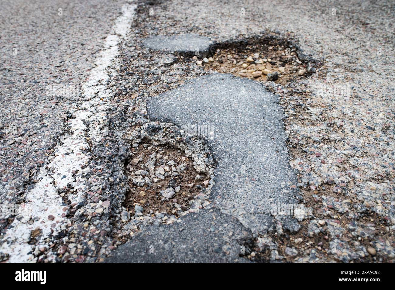 The texture of cracked old asphalt in need of repair. The road is full ...