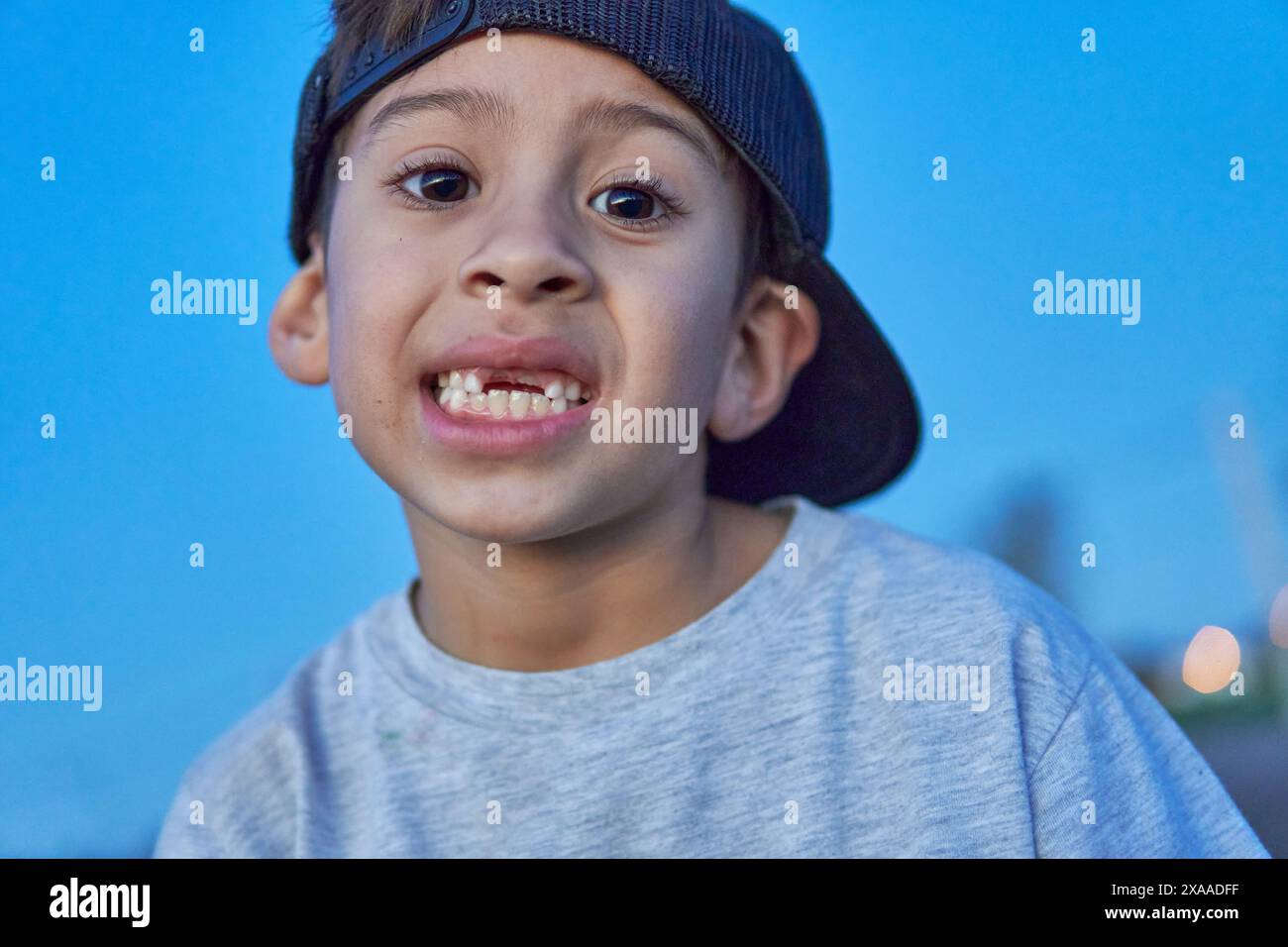 portrait of latin boy with cap showing his missing baby teeth in the ... portrait of latin boy with cap showing his missing baby teeth in the ...