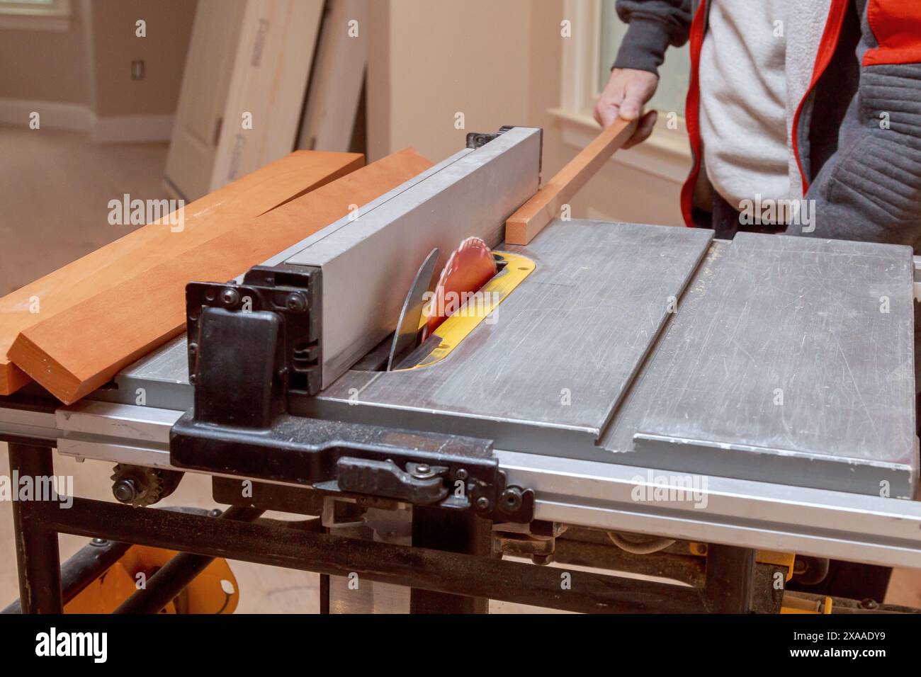 Using an electric table saw to cut wood cabinet filler Stock Photo - Alamy