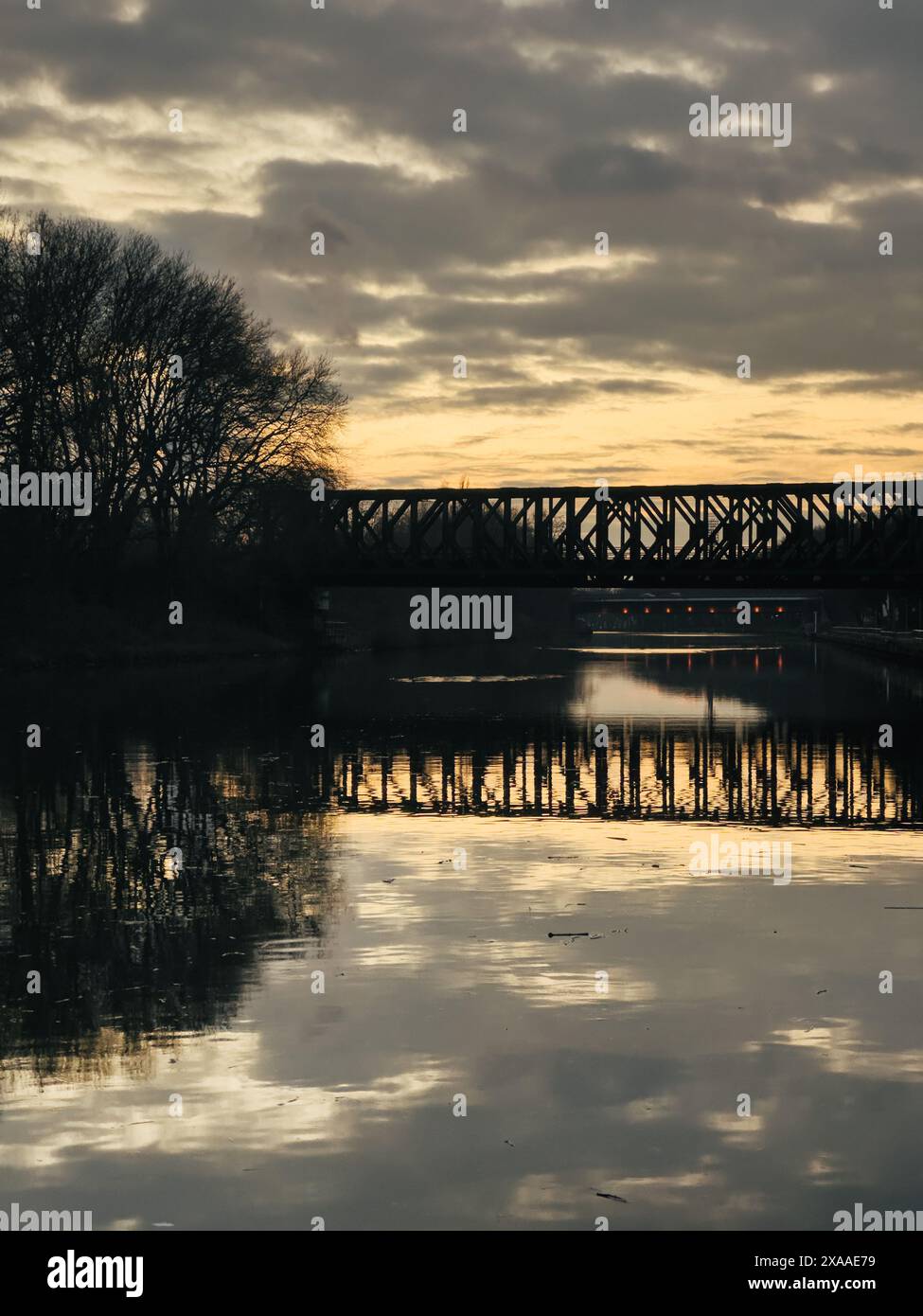 Bridge spanning river under sunset glow Stock Photo - Alamy