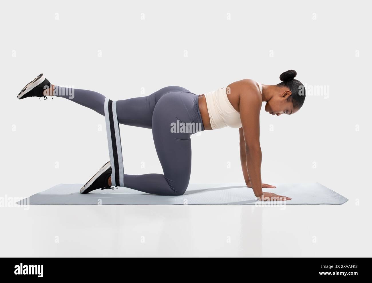 Woman Performing Glute Bridge Exercise With Resistance Band on Mat ...