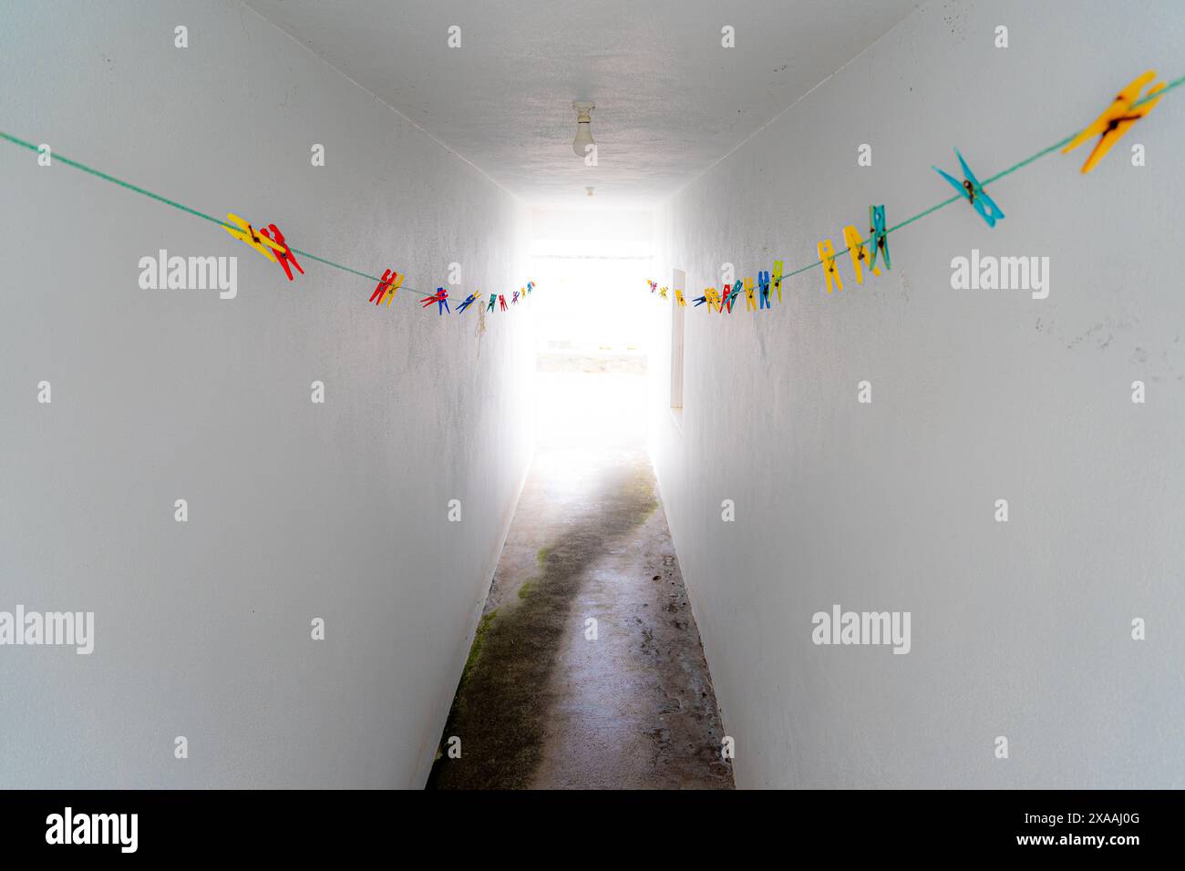 White corridor in the shape of a tunnel with clothes drying rack inside ...