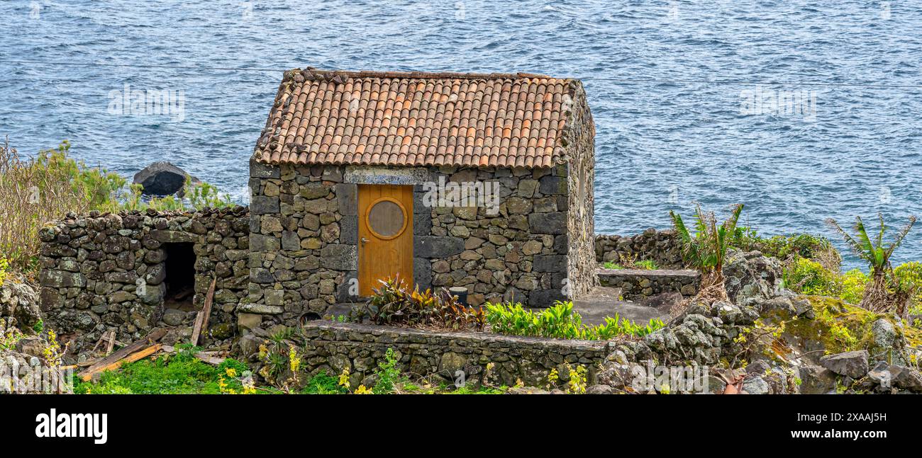Landscaped coastal area with typical stone houses in Fajã dos ...