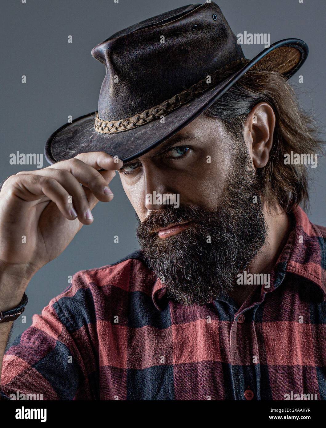 Handsome young man adjusting his cowboy hat. Cowboys in hat. Handsome ...
