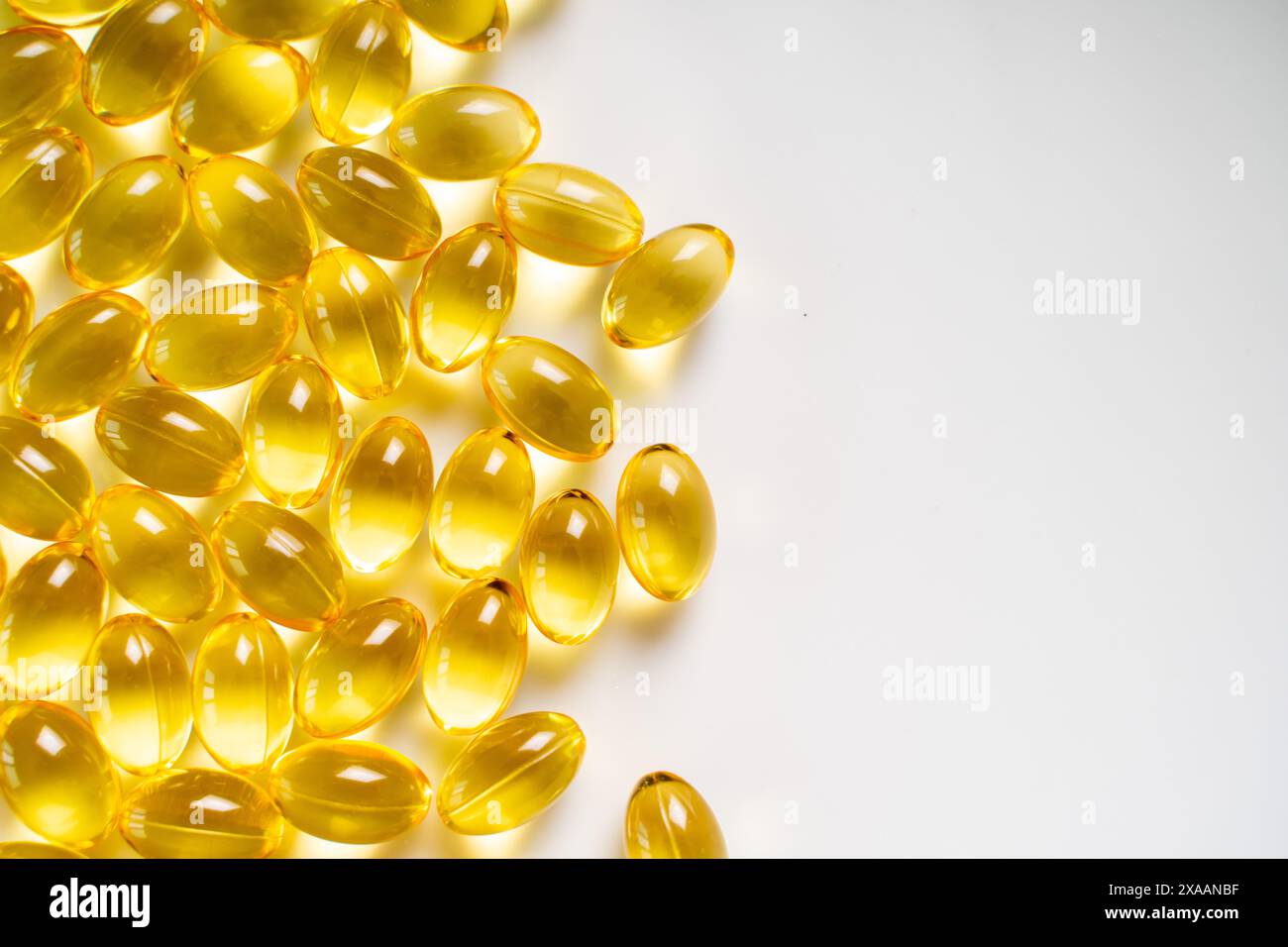 Lots of omega-3 fish oil tablets, bright yellow on a white background ...