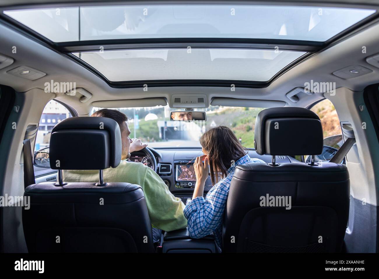 Rear back view from passenger seat of man and lady sitting inside car ...