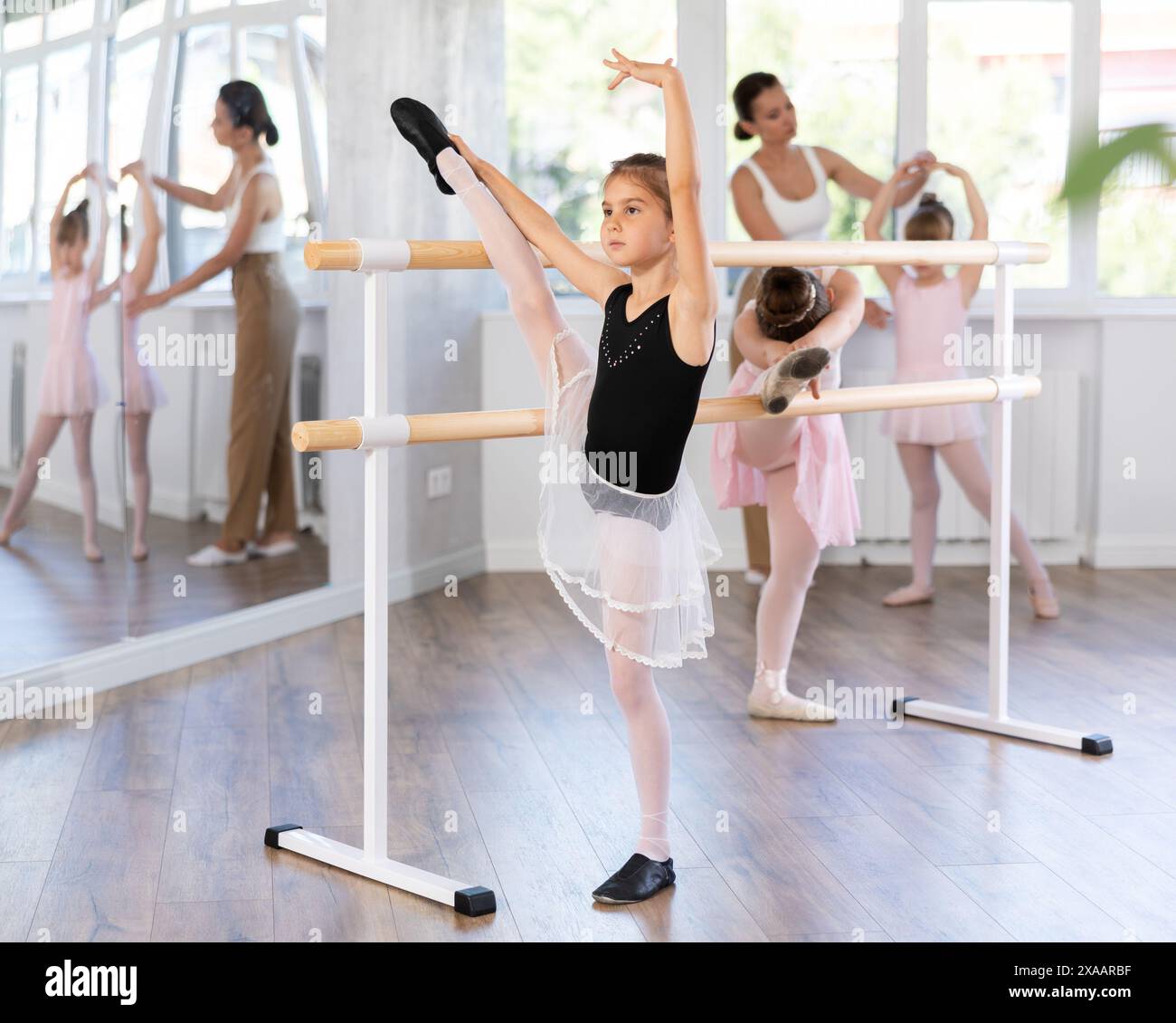 Girls dancers doing stretching at barre Stock Photo - Alamy