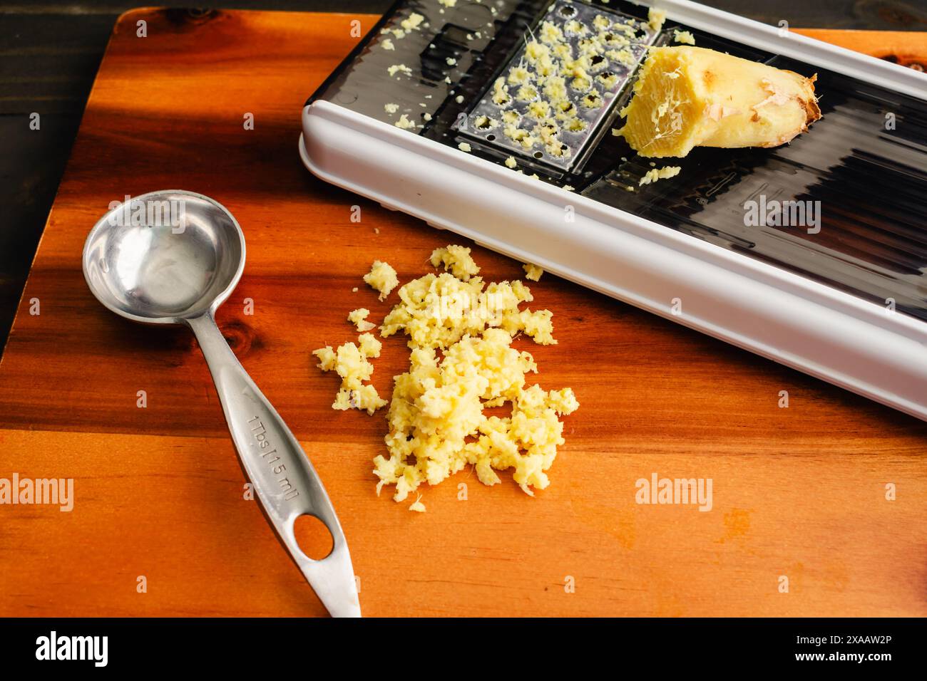 Grated Ginger with a Grater: A tablespoon of grated ginger on a wooden ...