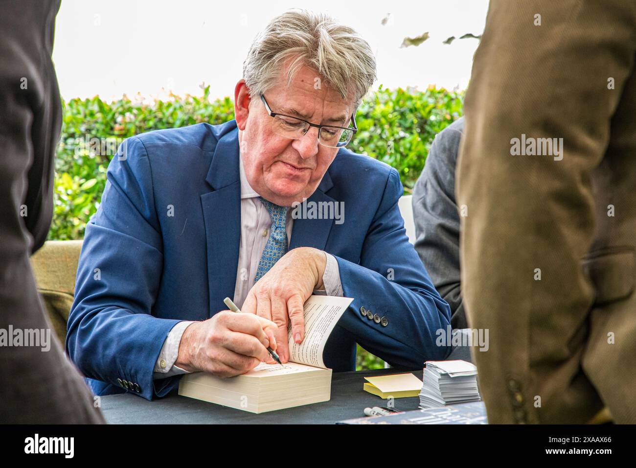 Head and shoulders image of Robert Hardman seated at a table signing ...