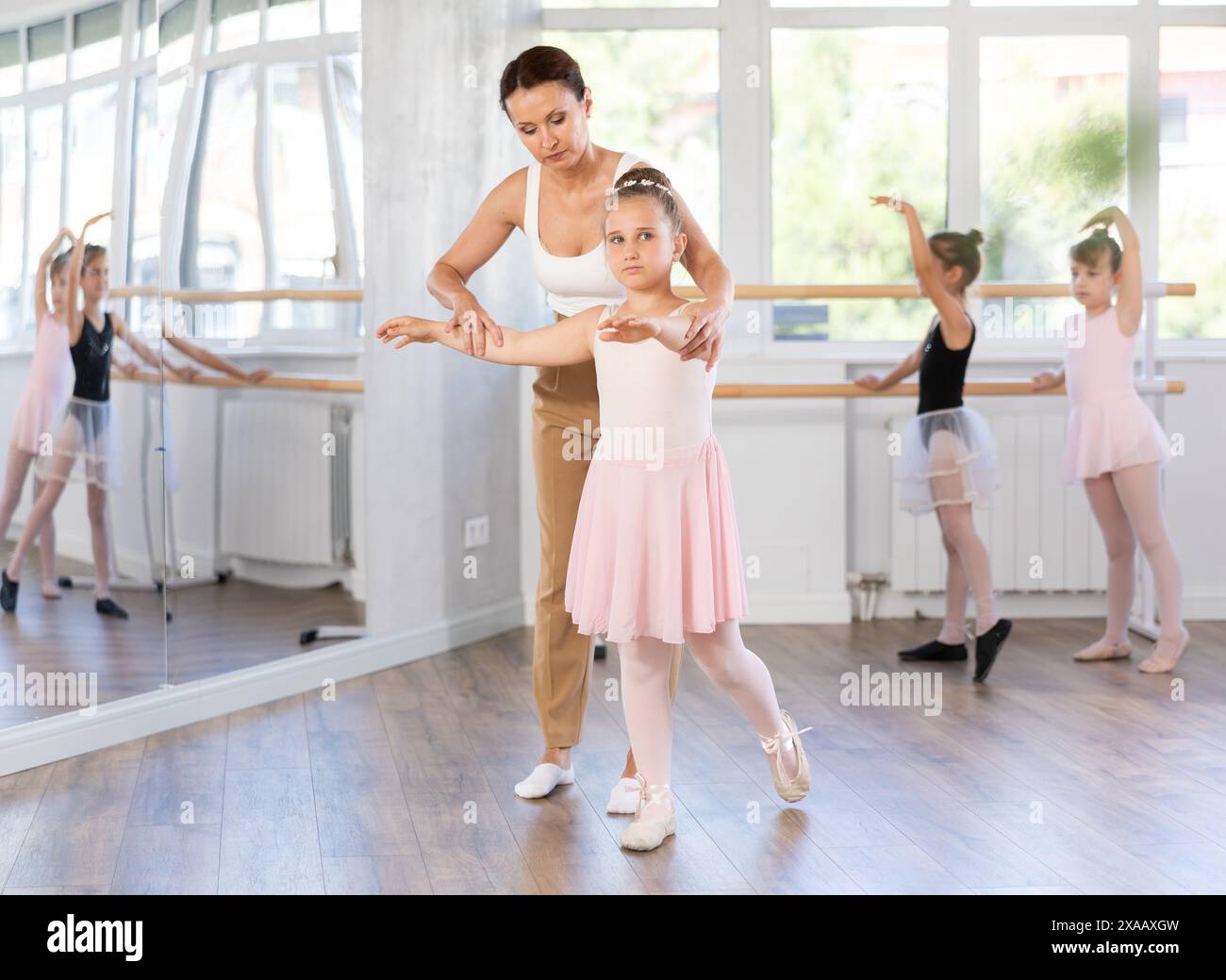 Woman teacher choreographer patiently teaches little girls the basics ... Woman teacher choreographer patiently teaches little girls the basics ...
