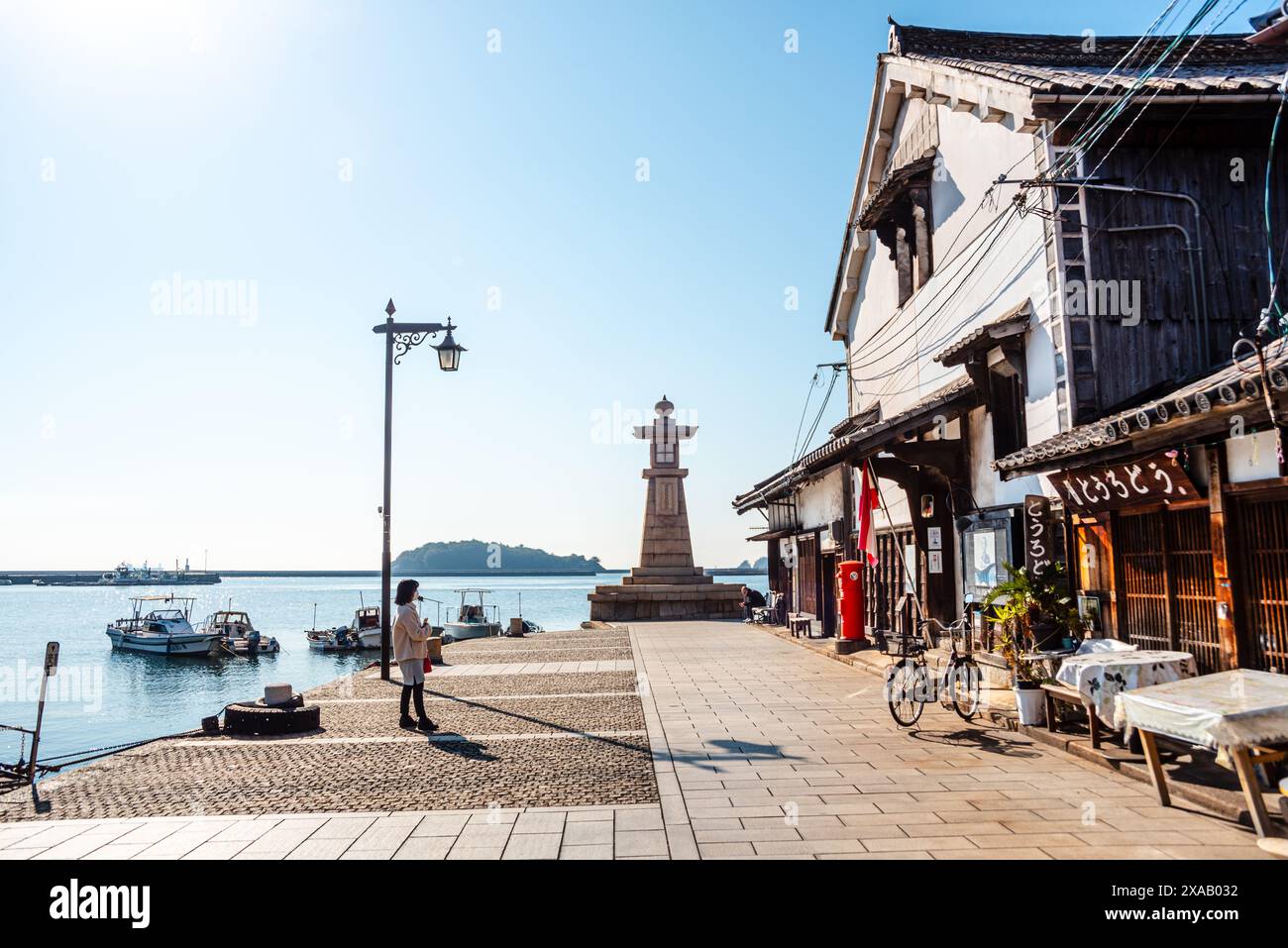 Iconic stone lighthouse at the port of the traditional fishing village ...