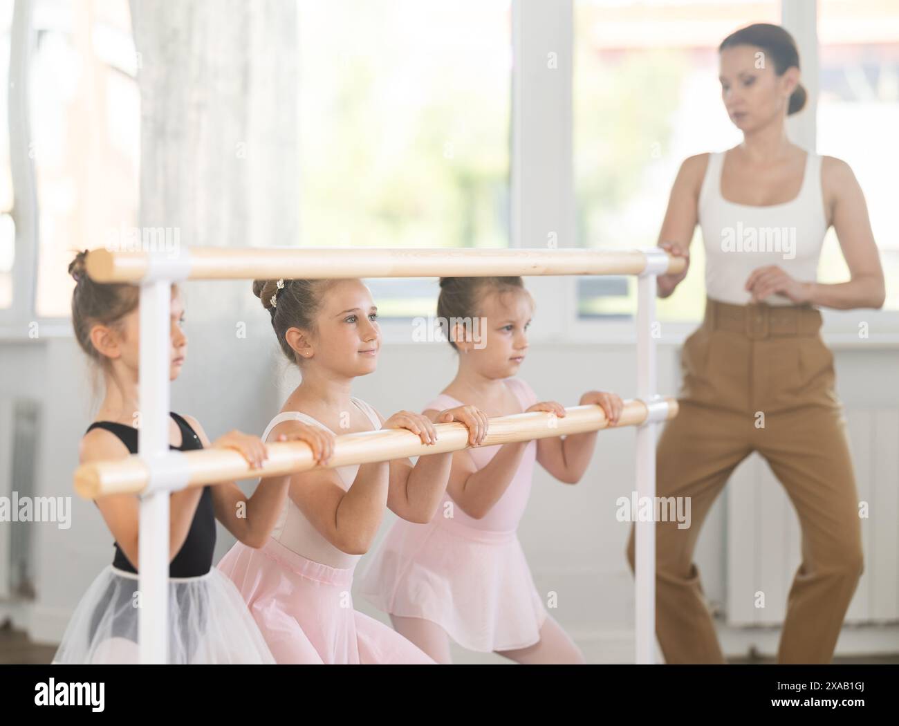 Little girls doing ballet at group training session in the studio ...