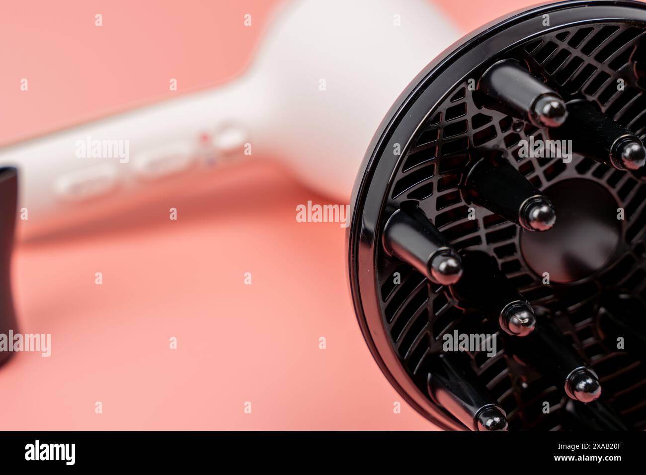 Hair dryer for drying hair on a pink background. The buttons are ...