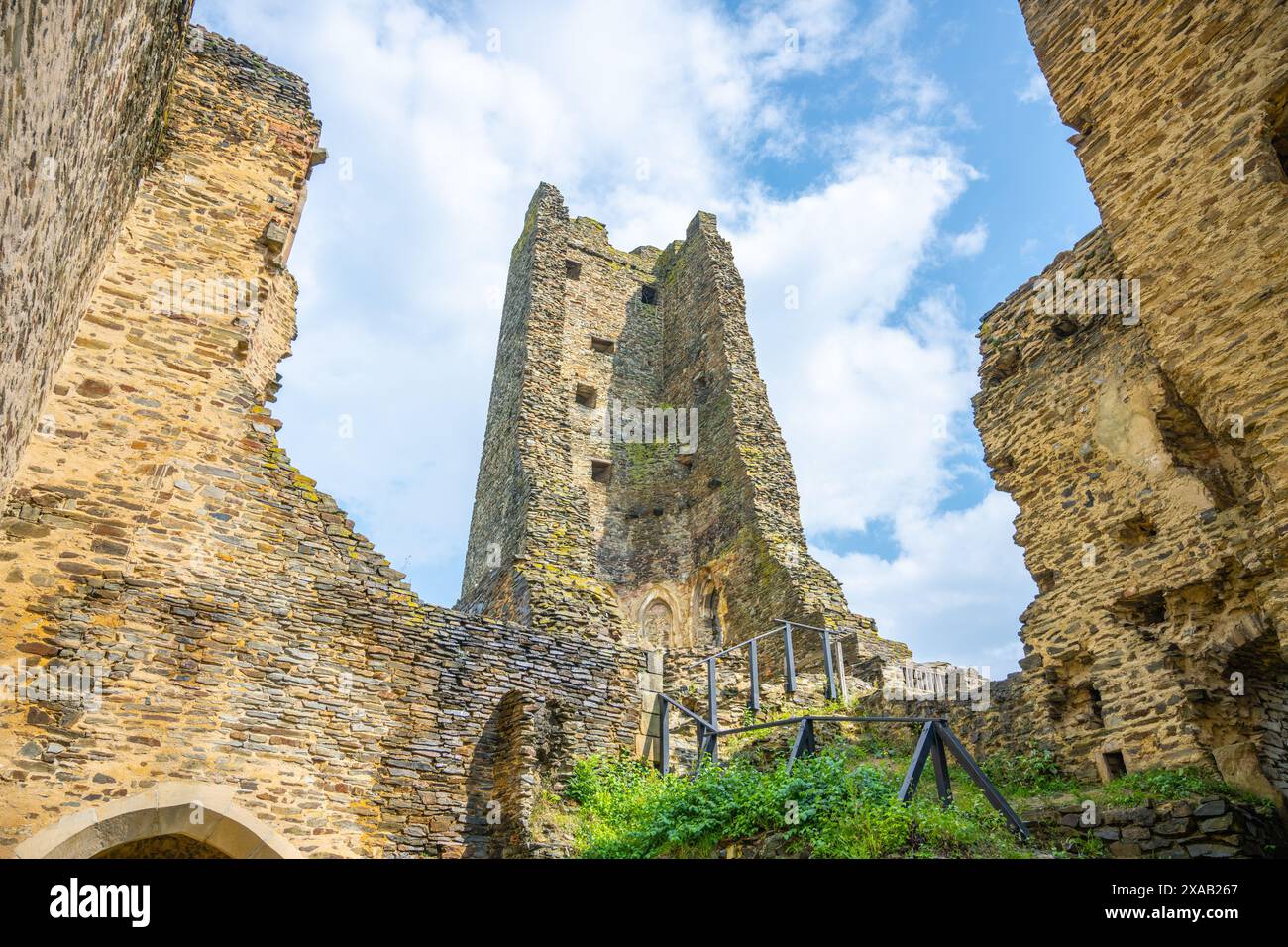 The ancient walls of Okor Castle stand tall against a clear blue sky ...
