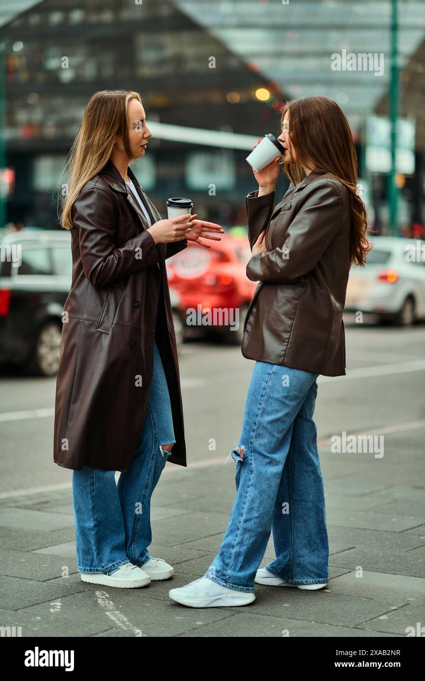 Two businesswomen enjoying a coffee break outside their office Stock ...