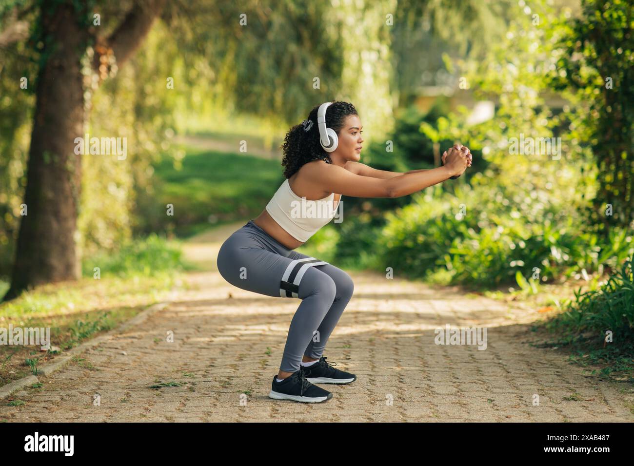 Fitness woman squatting city park hi-res stock photography and images ...