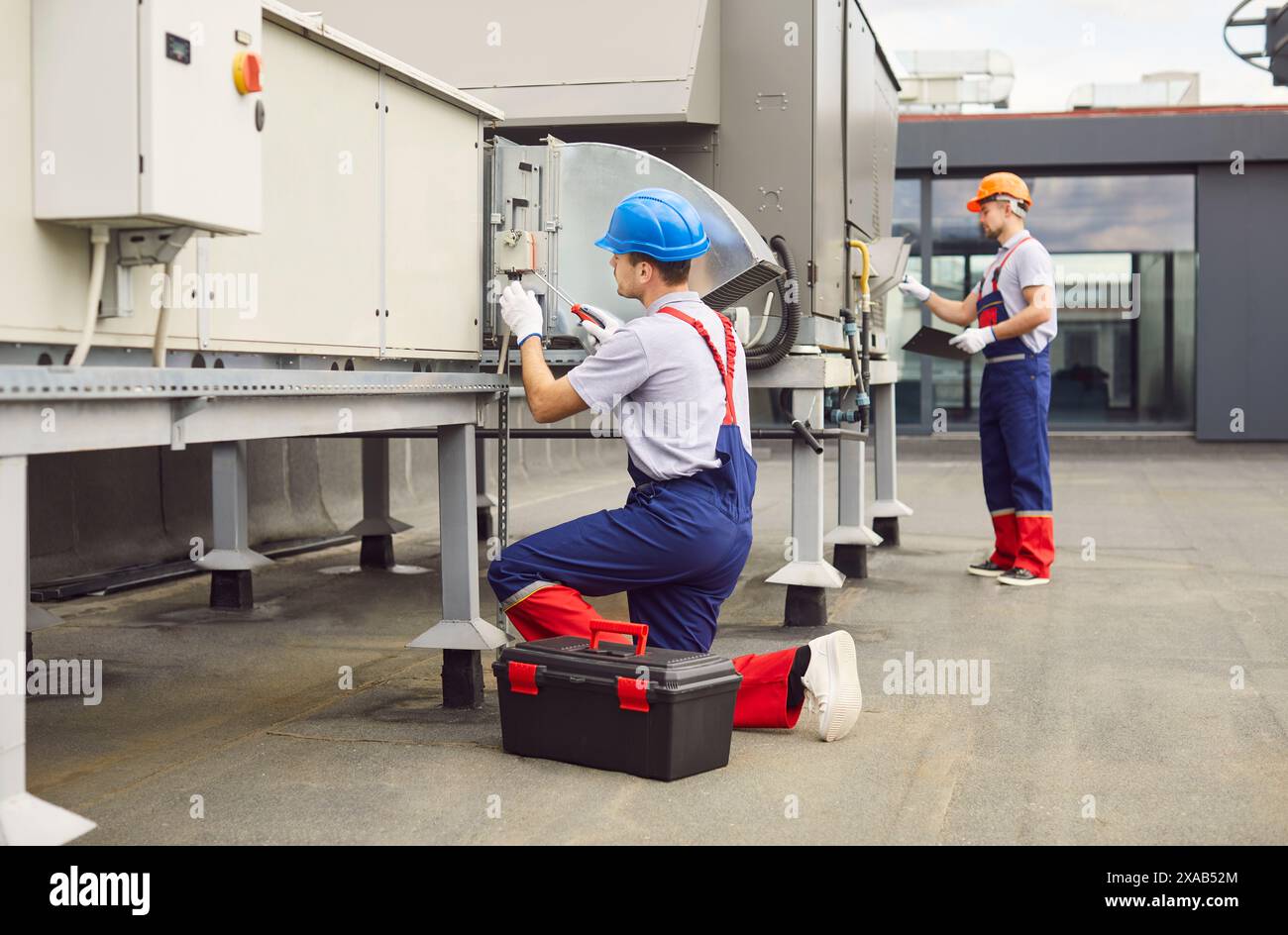 Workers Repairing Or Servicing Hvac And Ventilation Equipment On Roof ...