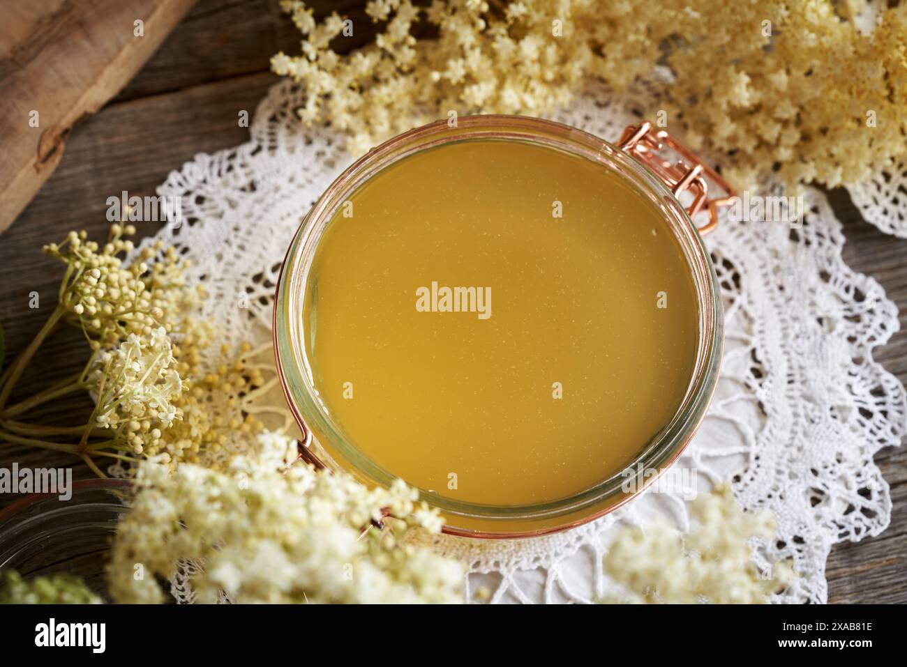 A jar of homemade elderberry flower syrup with fresh Sambucus nigra ...