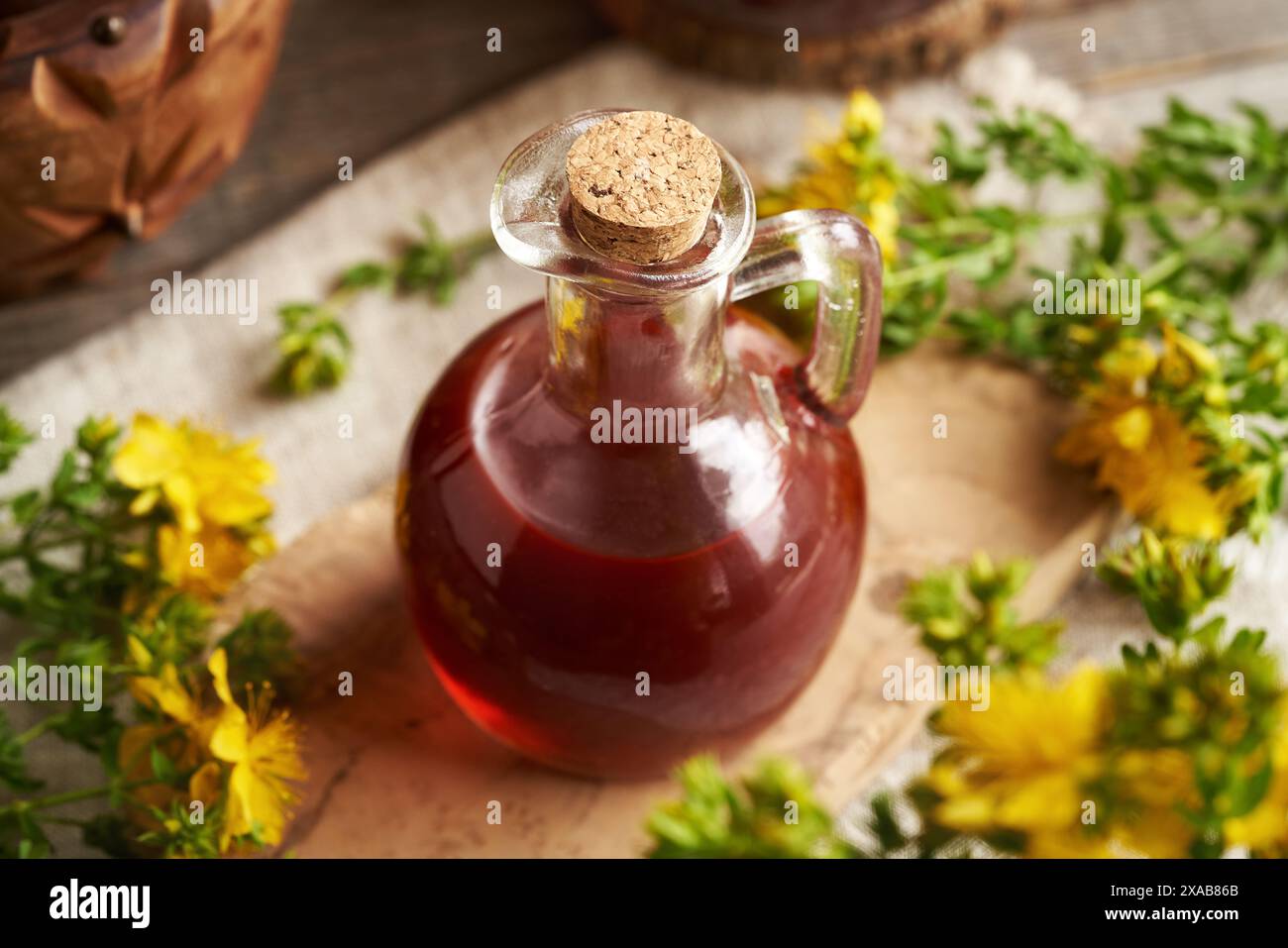 Homemade red St. John's wort oil in a glass jar with yellow Hypericum ...