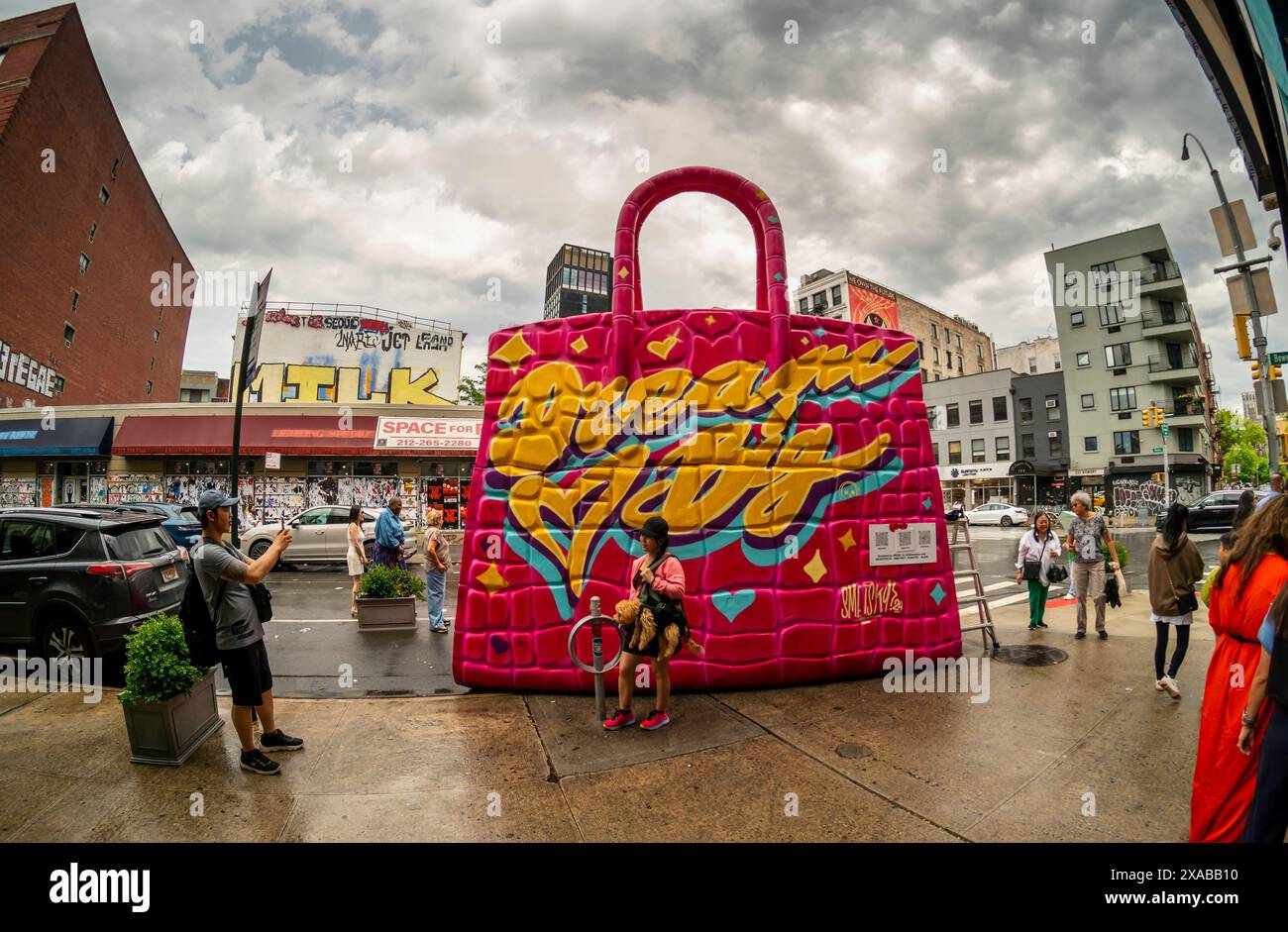 Passer-by pose in front of a giant Hermés Birkin bag installation in ...