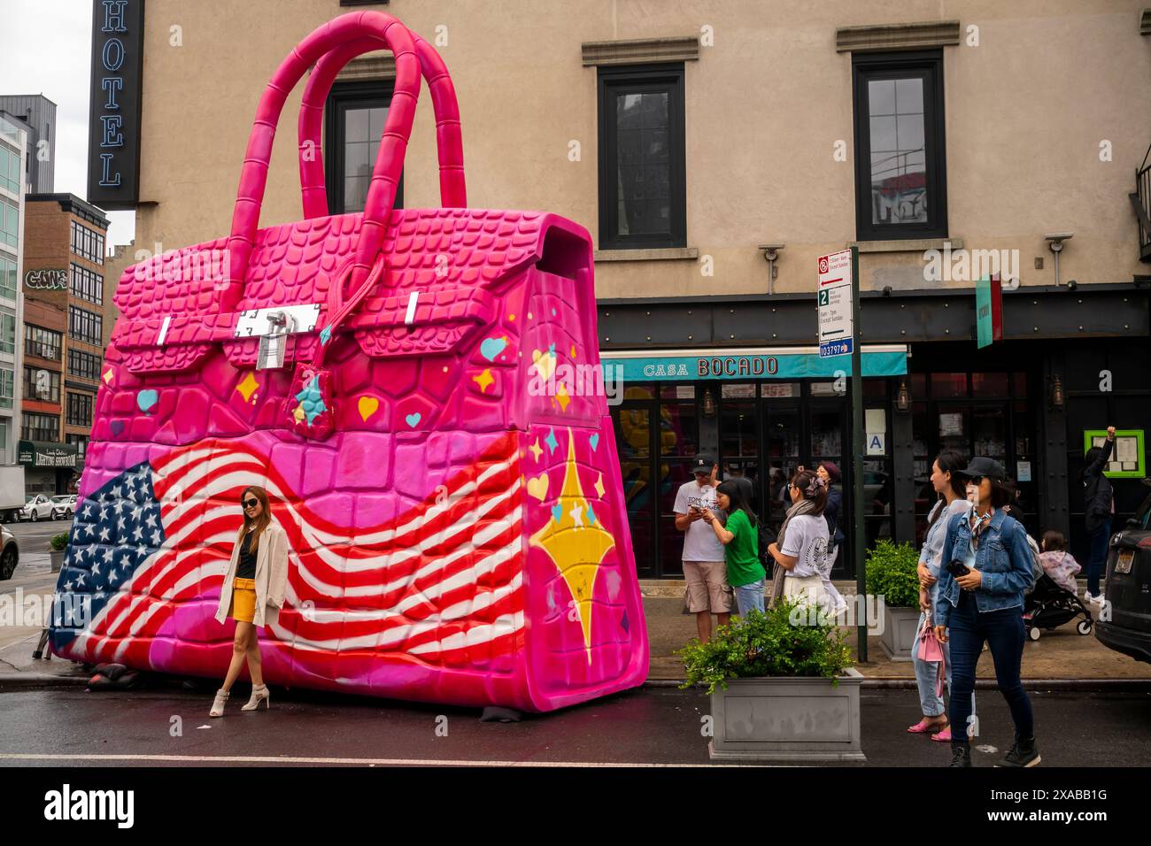 Passer-by pose in front of a giant Hermés Birkin bag installation in ...