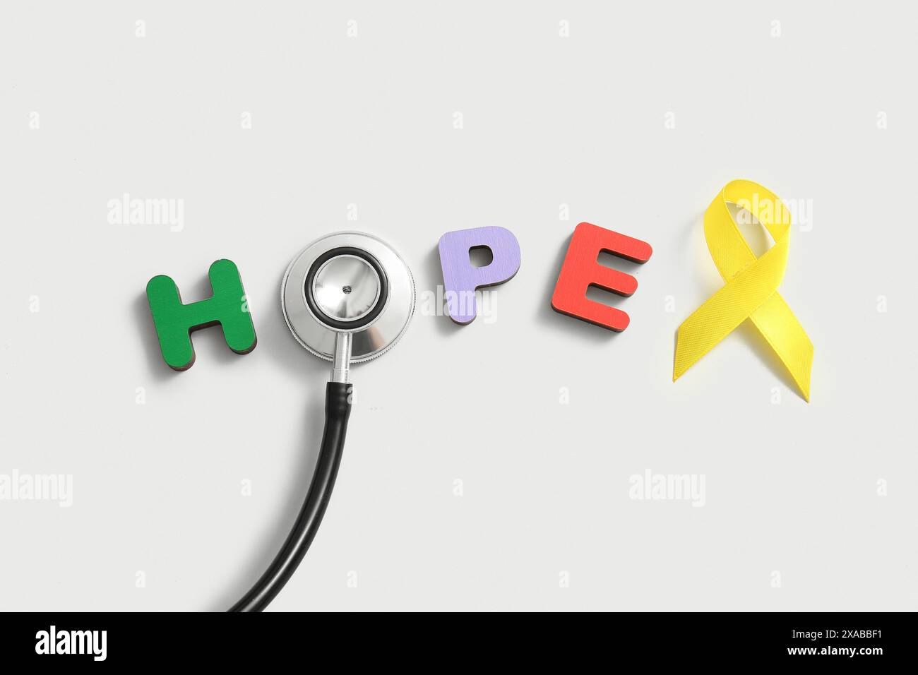 Yellow ribbon, stethoscope and color letters HOPE on light background ...