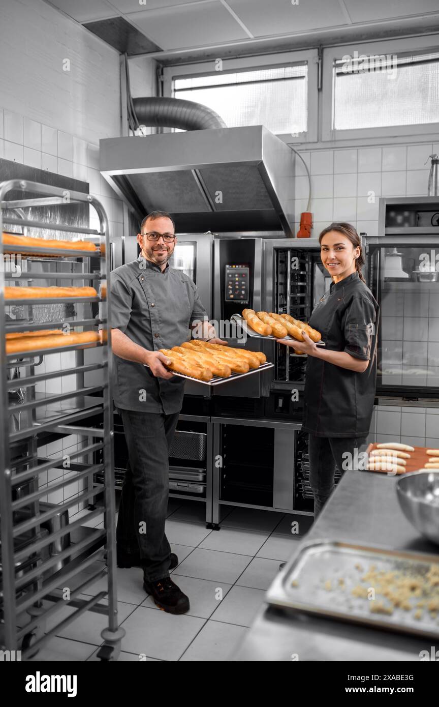 Professional bakers preparing fresh baguette in small bakery Stock ...