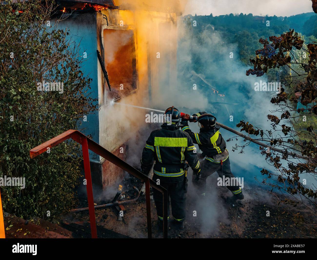Firefighter extinguish fire in house using spraying hose Stock Photo ...