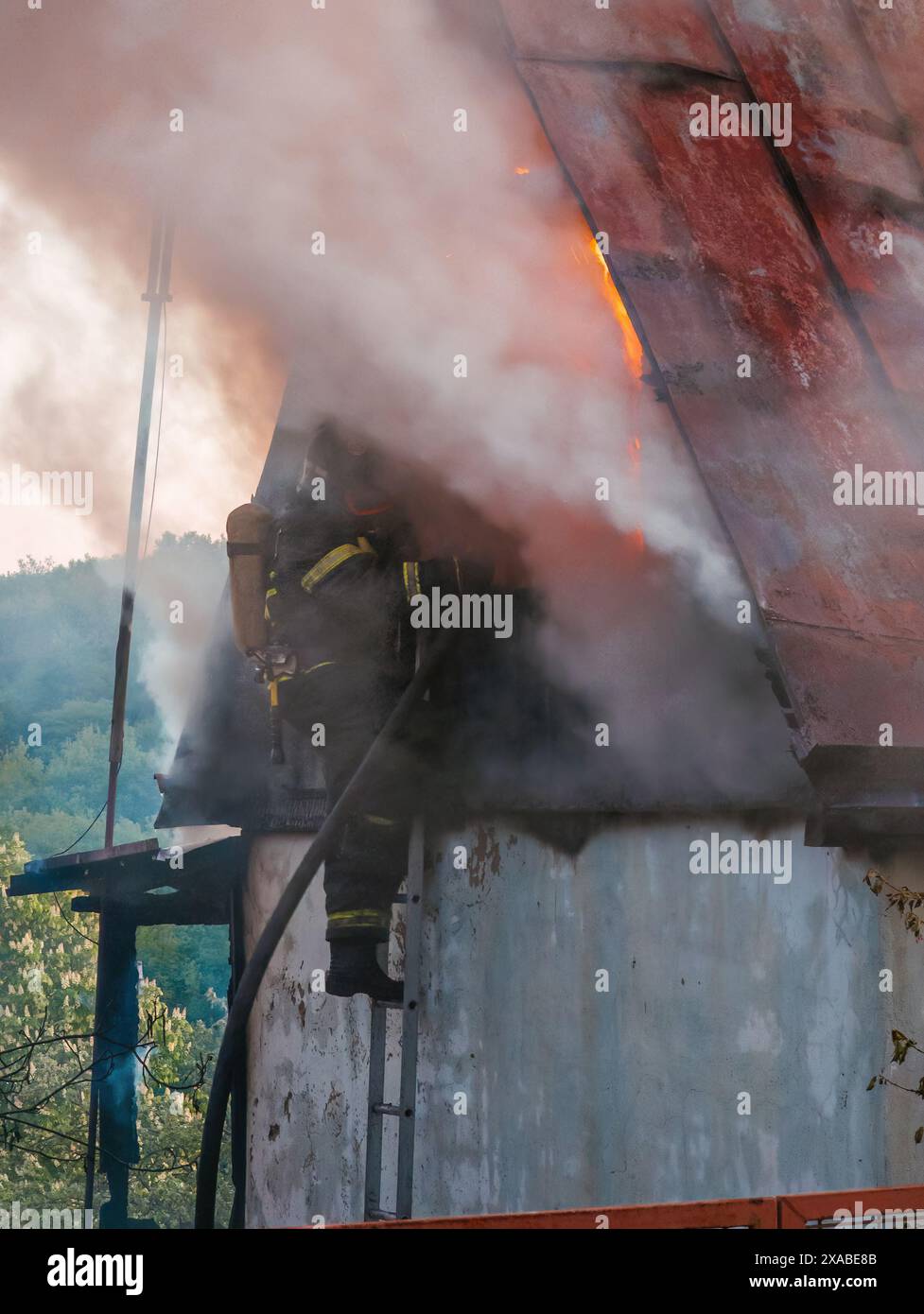 Firefighter extinguish fire in house using spraying hose Stock Photo ...