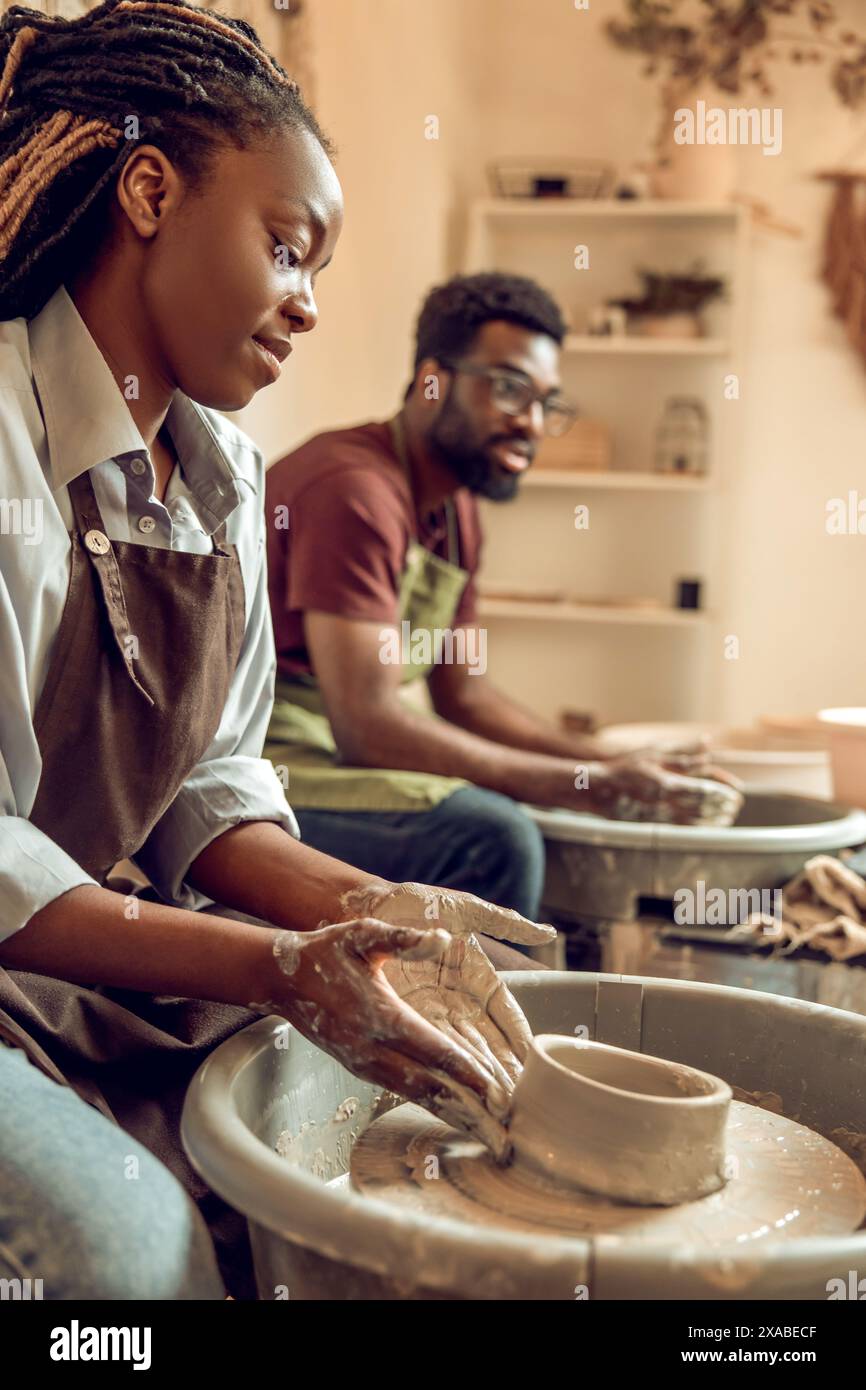 Two african american sculptors working on a pottery wheel Stock Photo ...