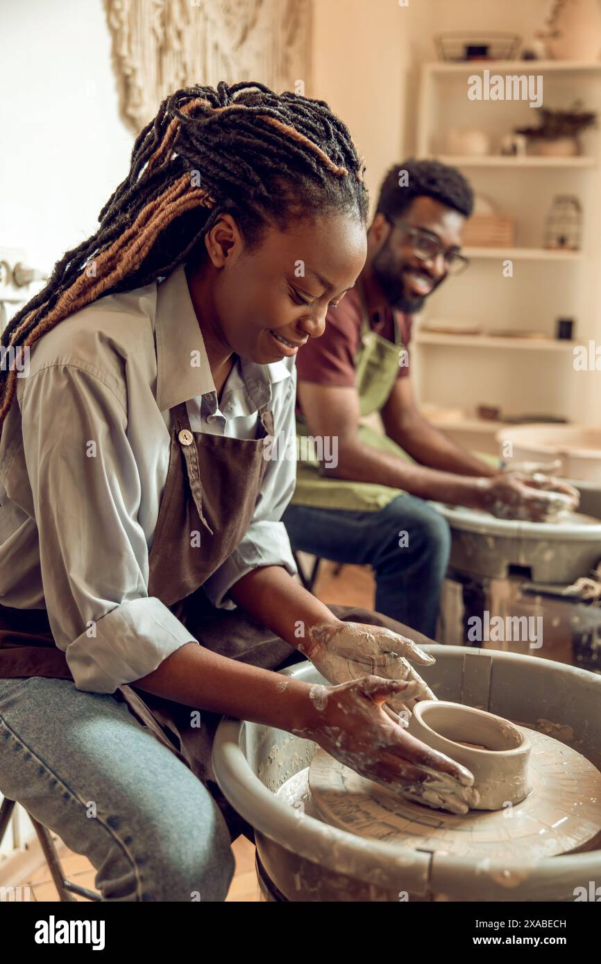 Two african american sculptors working on a pottery wheel Stock Photo ...