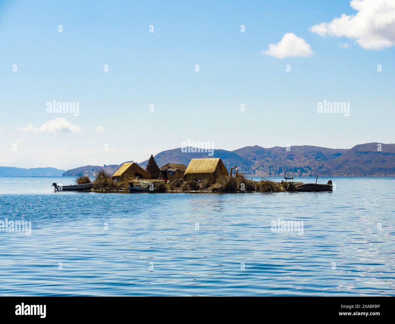 Traditional reed houses on the uros islands, with the serene waters of ...
