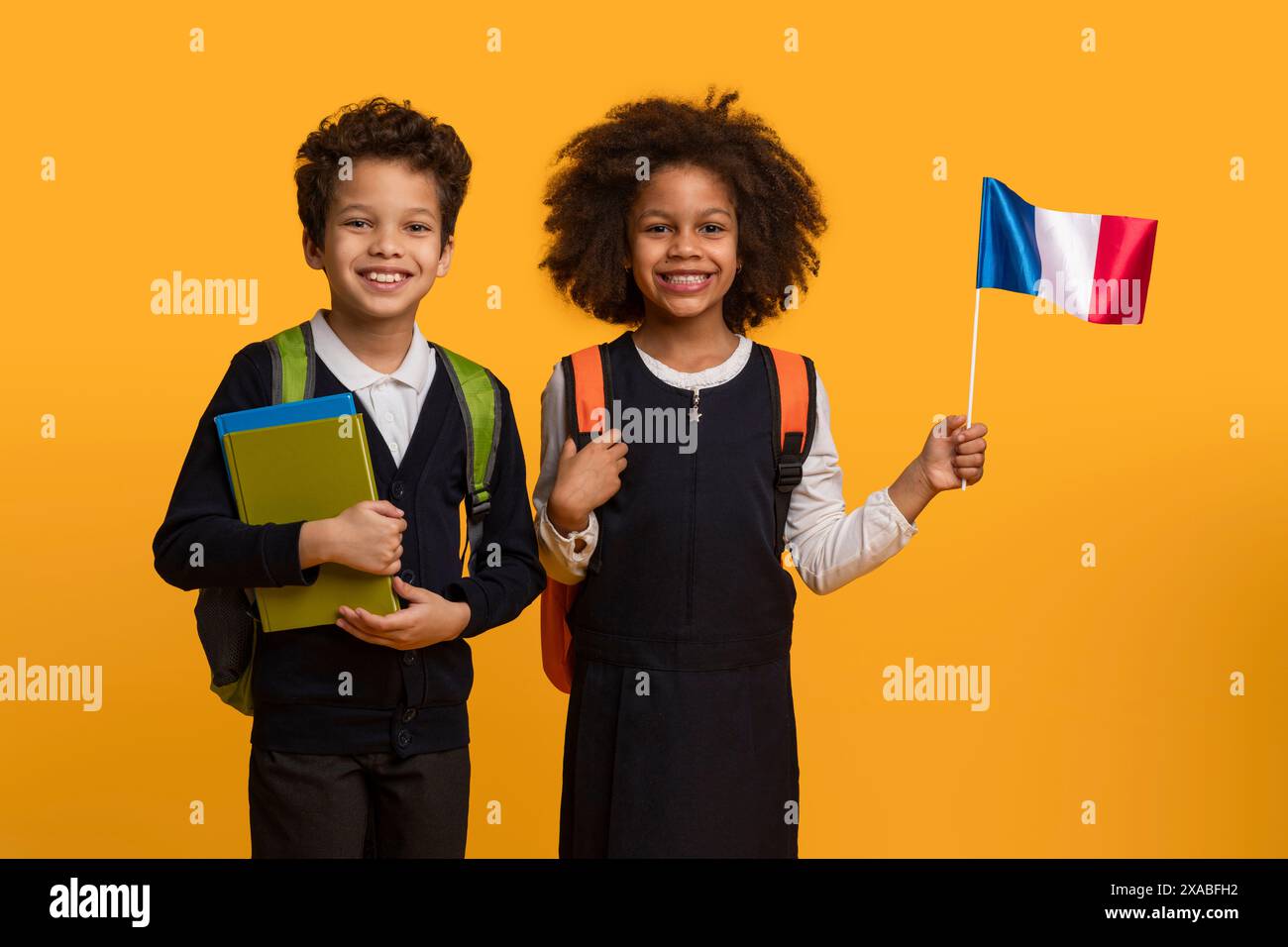 Two Students Holding Books and French Flag Against Yellow Background ...