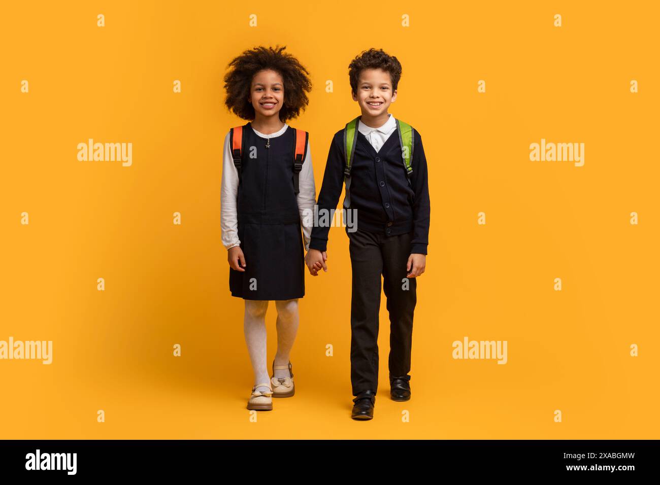 Smiling School Children Holding Hands On Yellow Background Stock Photo ...
