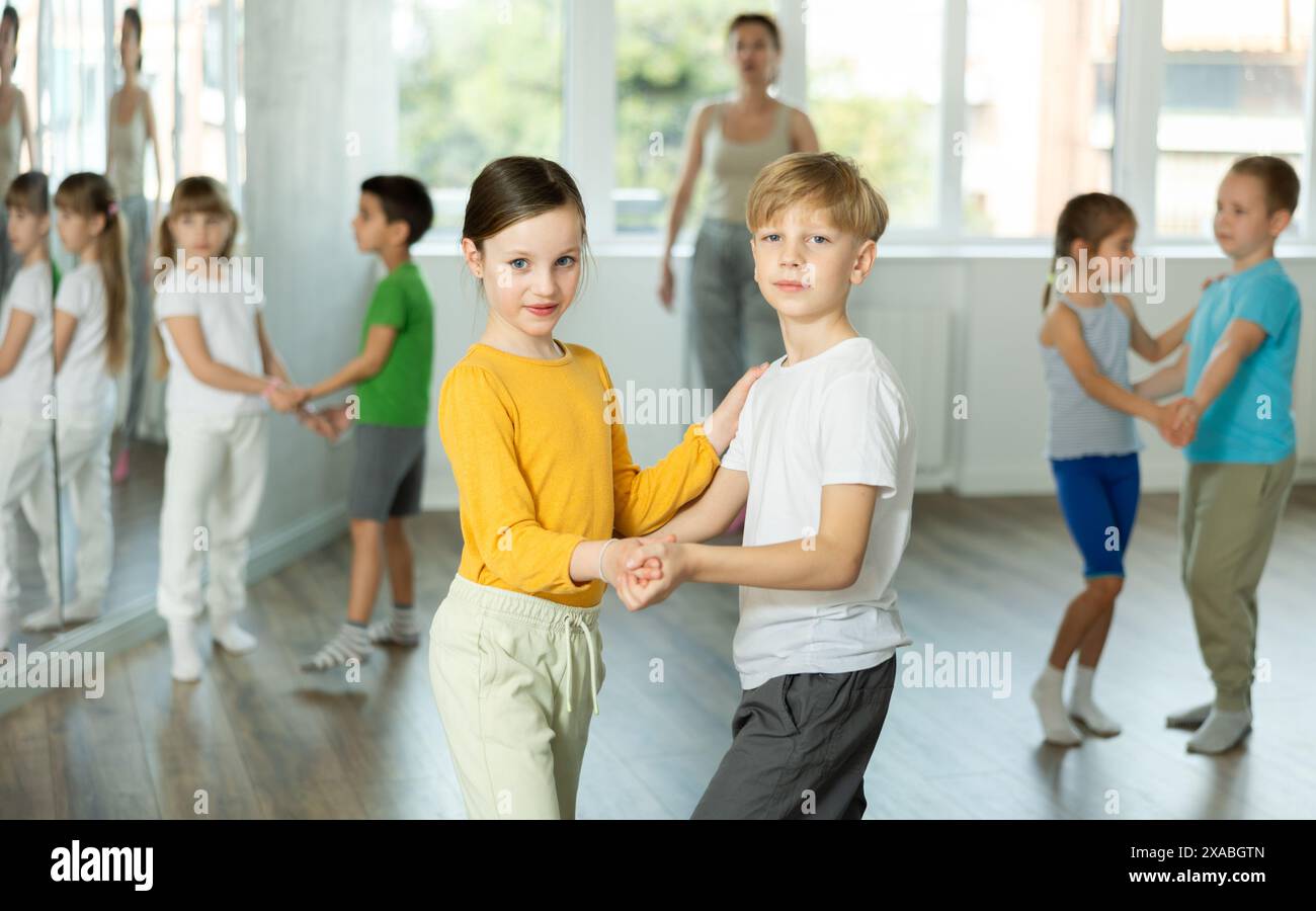 Preteen children learn to dance tango under guidance of a teacher in ...