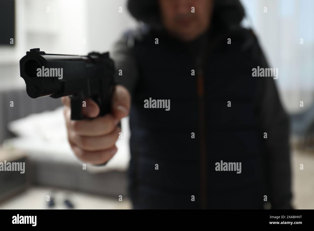 Dangerous criminal with gun in foreign house, selective focus. Armed ...