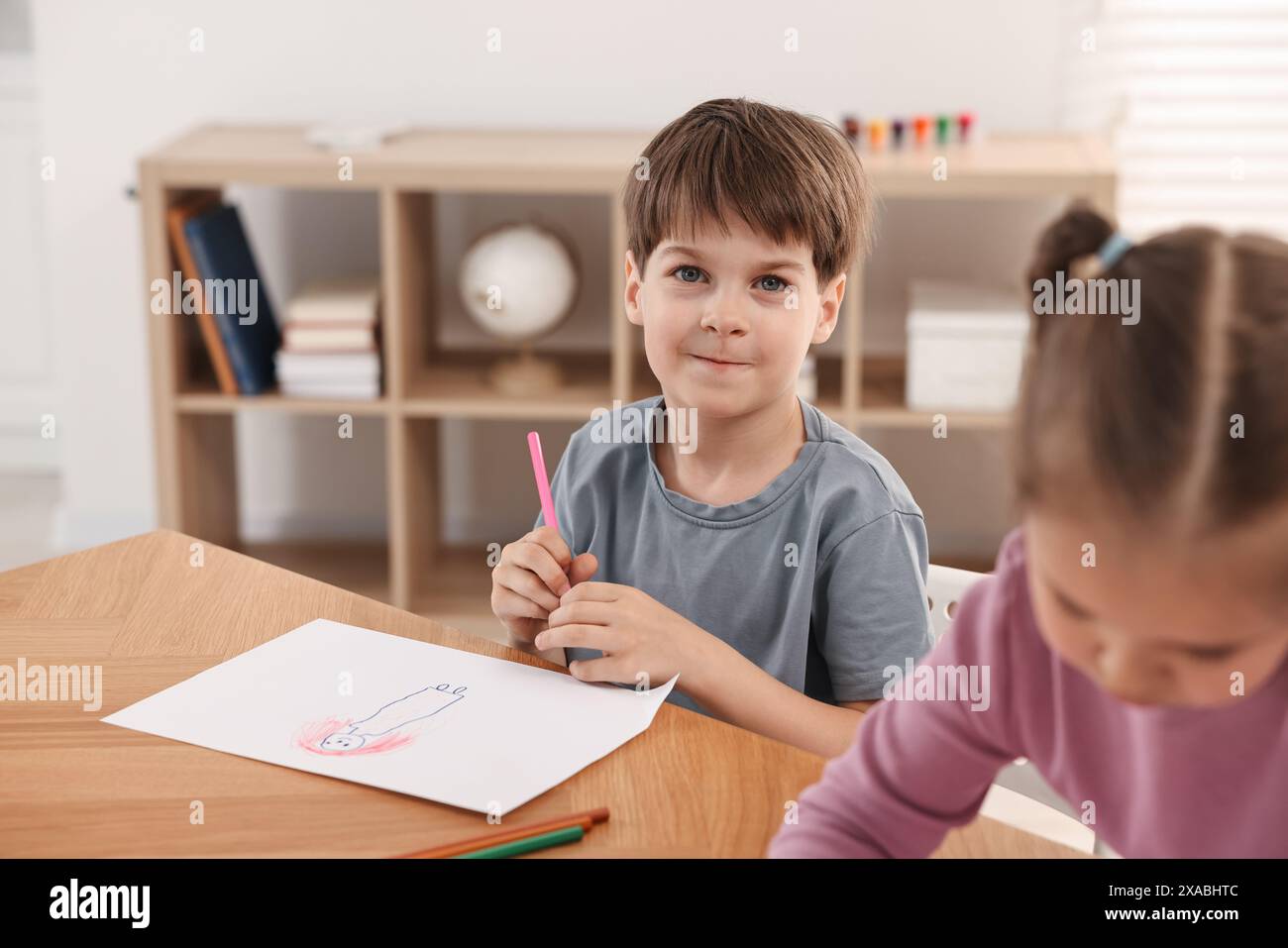 Cute little children drawing at wooden table indoors Stock Photo - Alamy