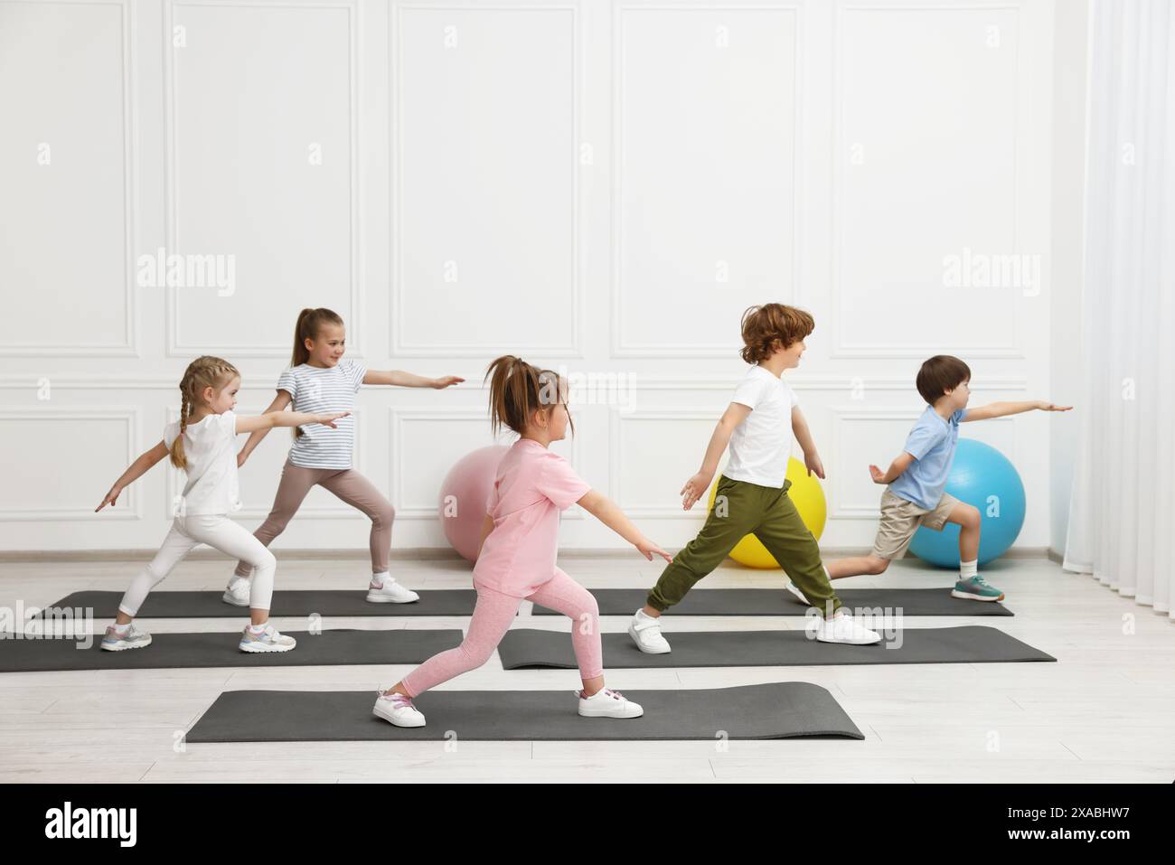 Group of children doing gymnastic exercises on mats indoors Stock Photo ...