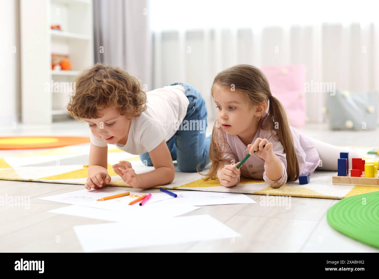 Cute little children drawing on floor in kindergarten Stock Photo - Alamy