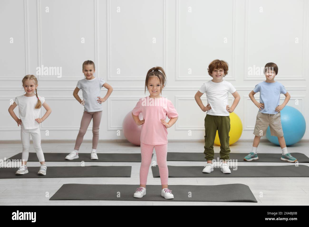 Group of children doing gymnastic exercises on mats indoors Stock Photo ...
