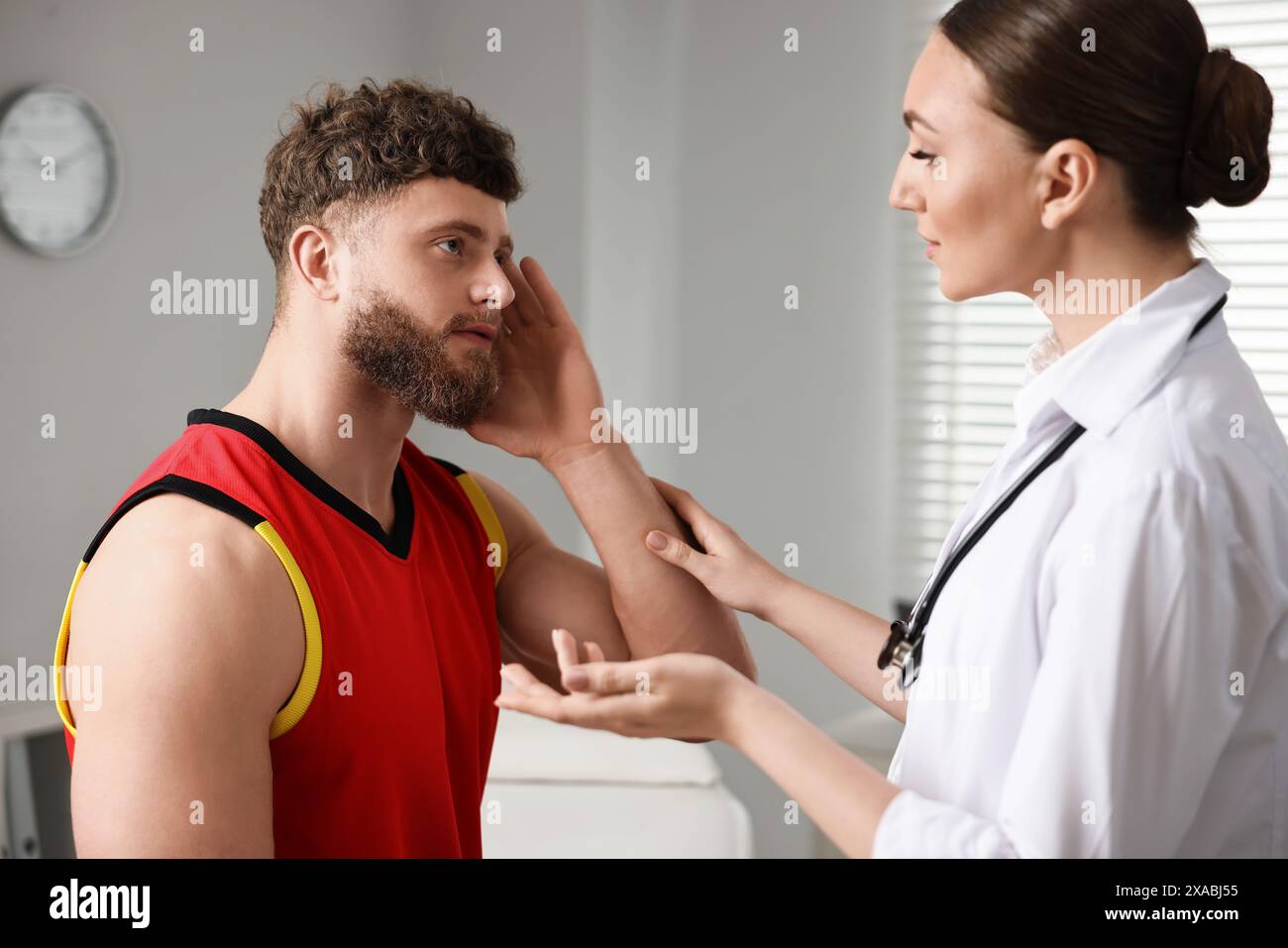 Sports injury. Doctor consulting patient in hospital Stock Photo - Alamy