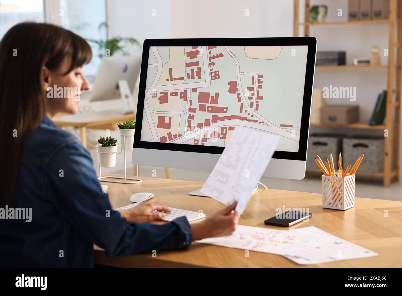 Cartographer working with cadastral maps at table in office Stock Photo ...