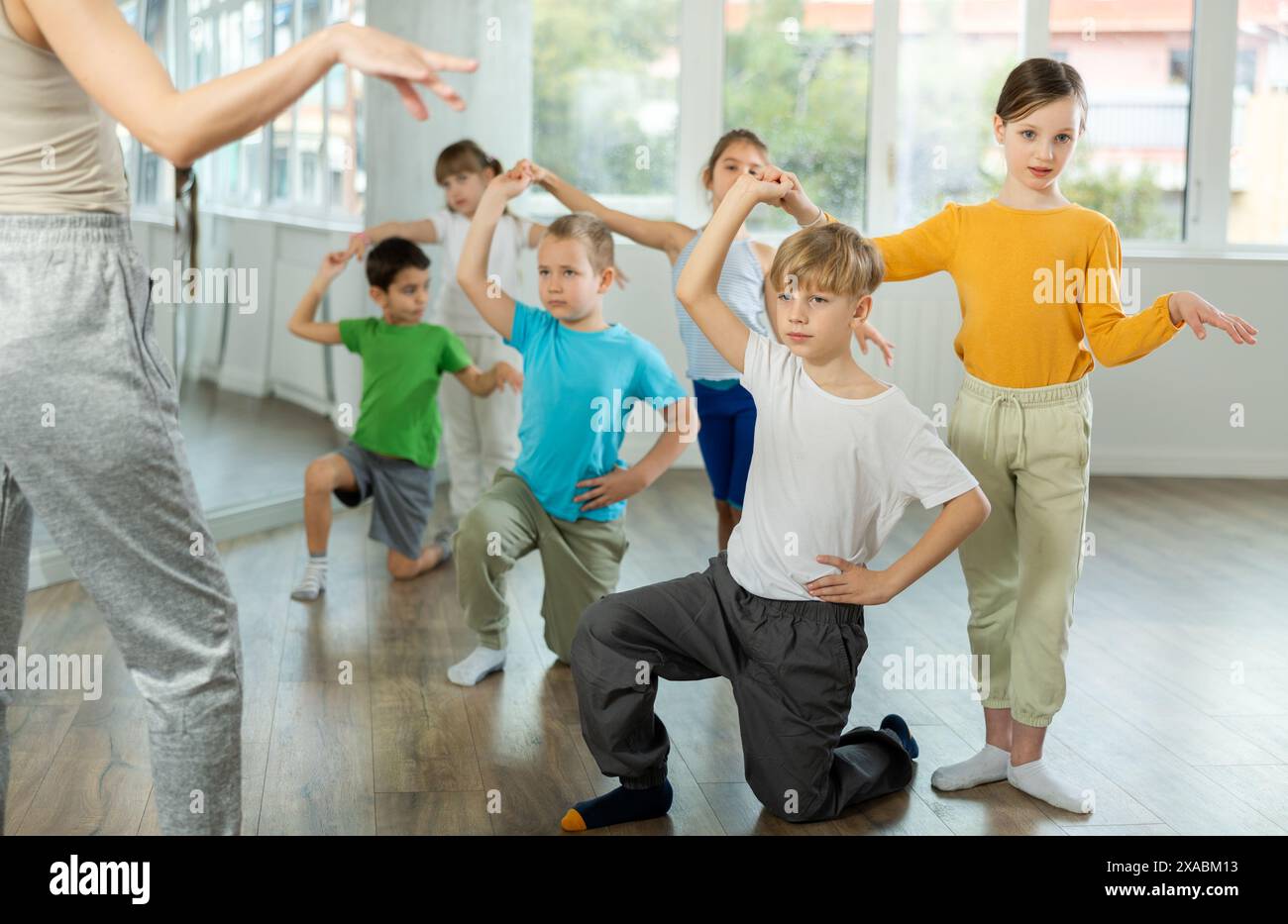 Happy preteen children practicing ballroom dances in pairs in training ...